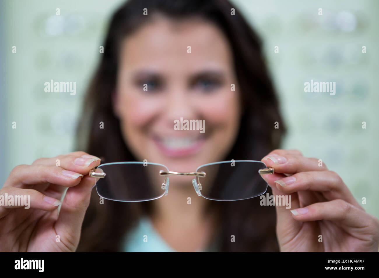 Female customer holding spectacles in optical store Stock Photo - Alamy