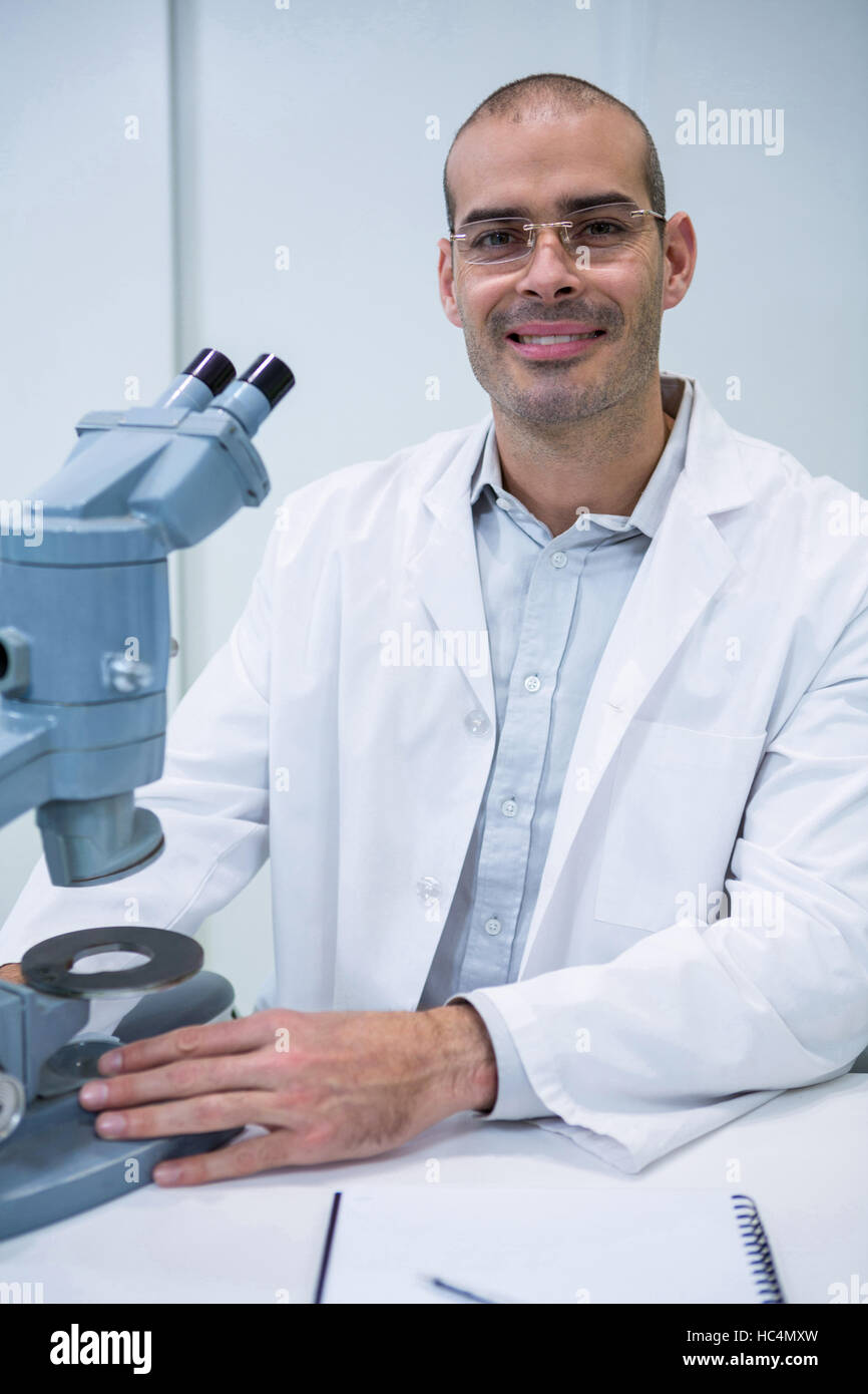 Smiling male optometrist with microscope Stock Photo - Alamy