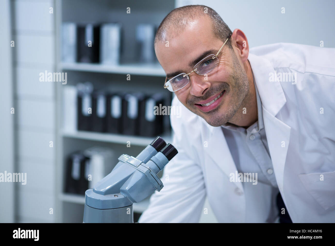 Smiling male optometrist with microscope Stock Photo - Alamy