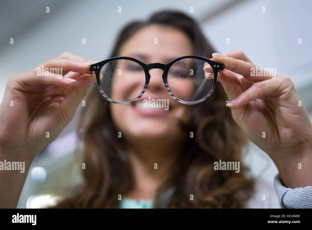 Female customer holding spectacles in optical store Stock Photo - Alamy