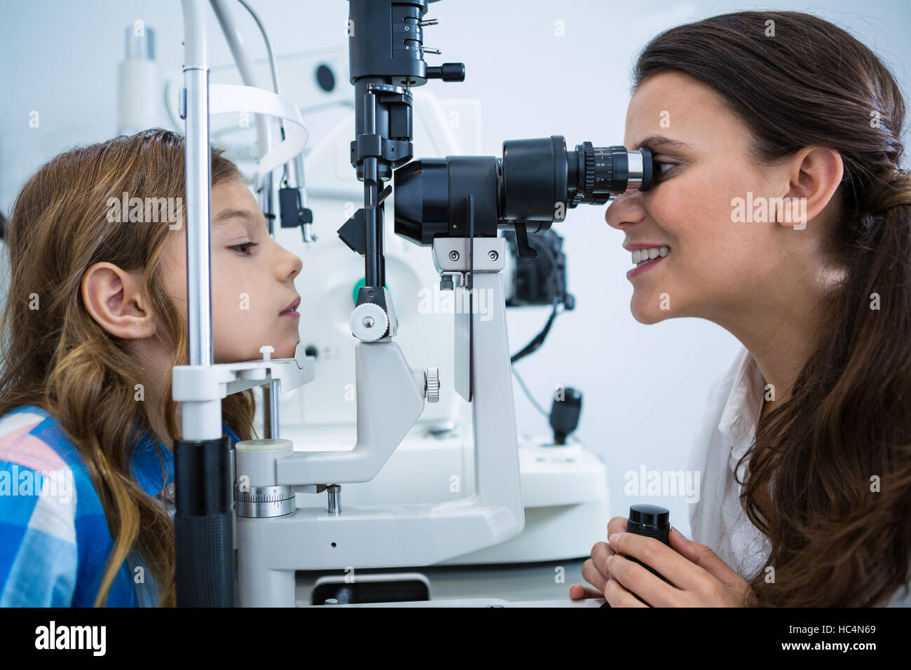 Female optometrist examining young patient on slit lamp Stock Photo - Alamy