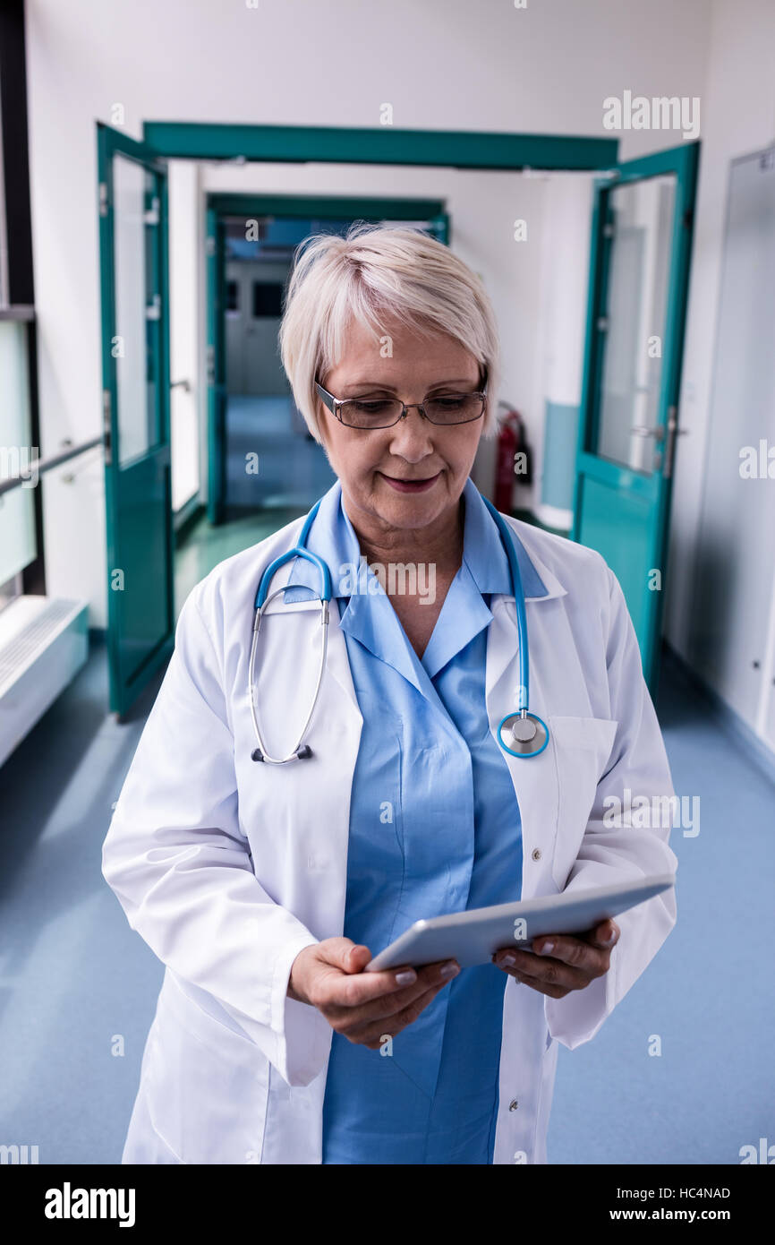 Doctor using digital tablet in corridor Stock Photo - Alamy