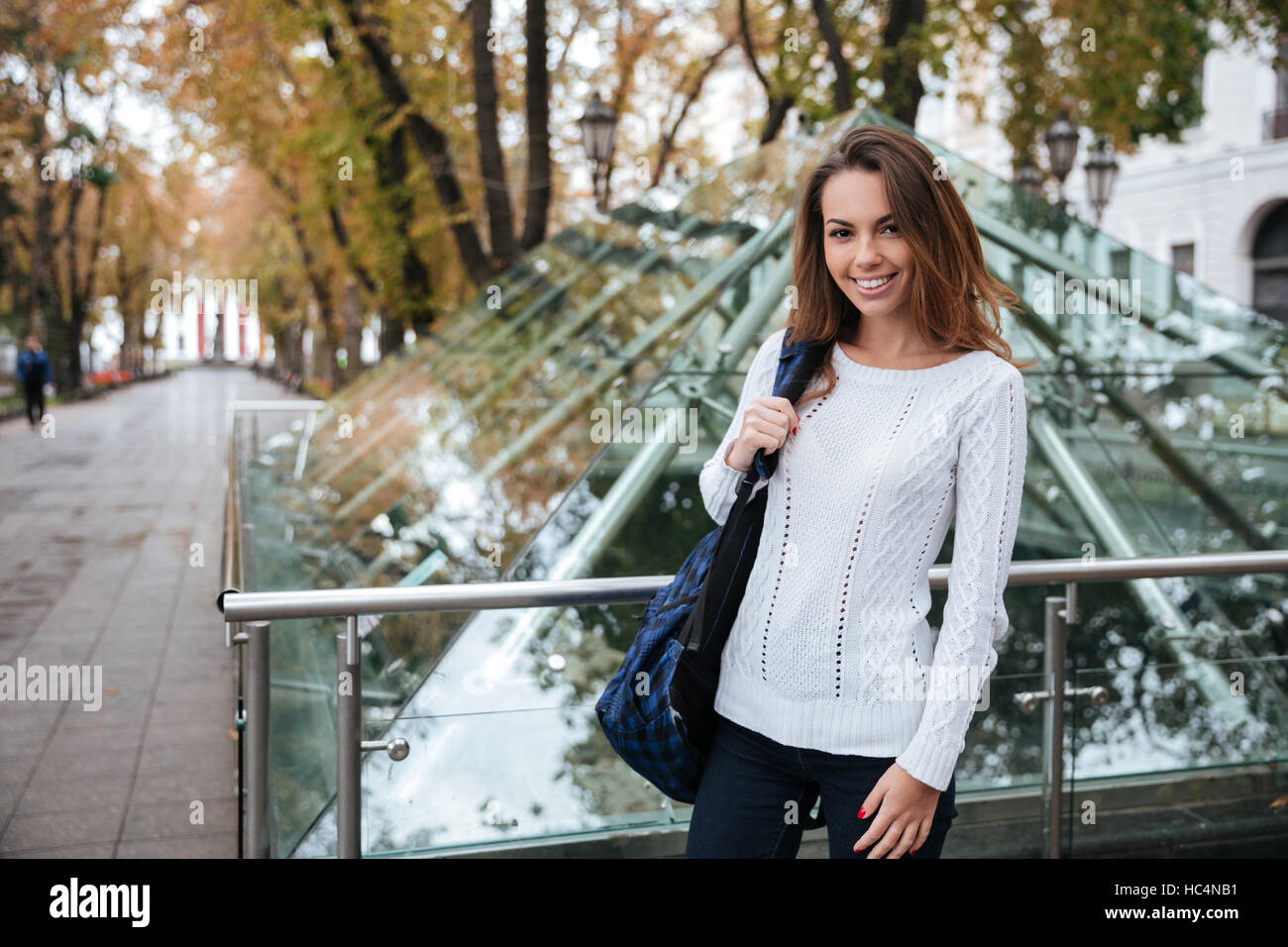 Happy beautiful young woman with backpack walking in the city Stock ...