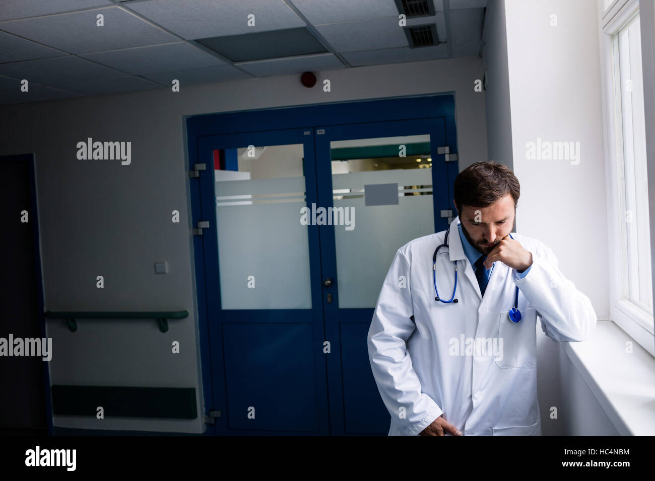 Sad doctor standing in corridor Stock Photo - Alamy