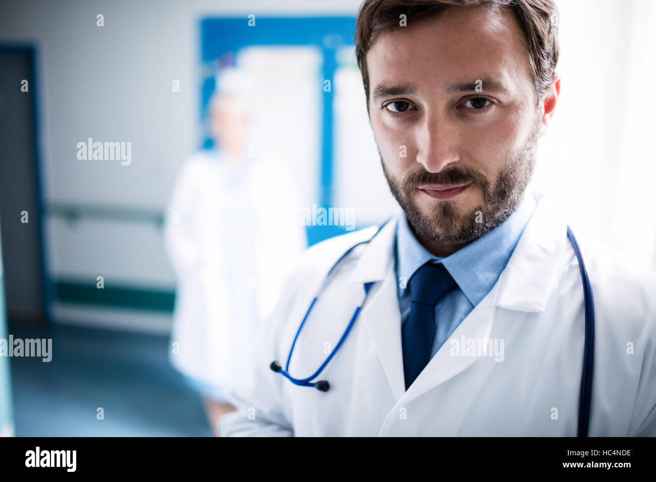 Confident doctor standing in hospital corridor Stock Photo - Alamy