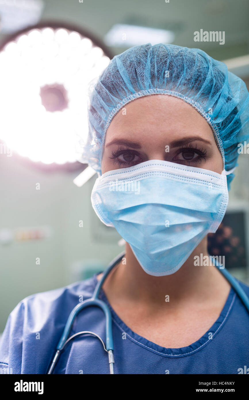 Portrait of surgeon wearing surgical mask in operation room Stock Photo ...