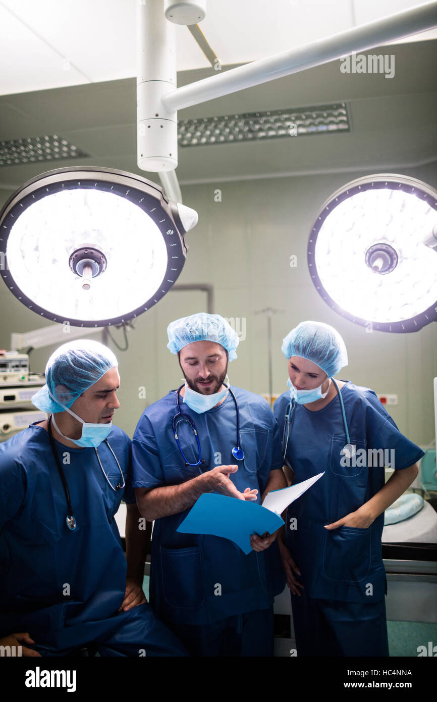 Surgeons discussing patient records in operation room Stock Photo - Alamy