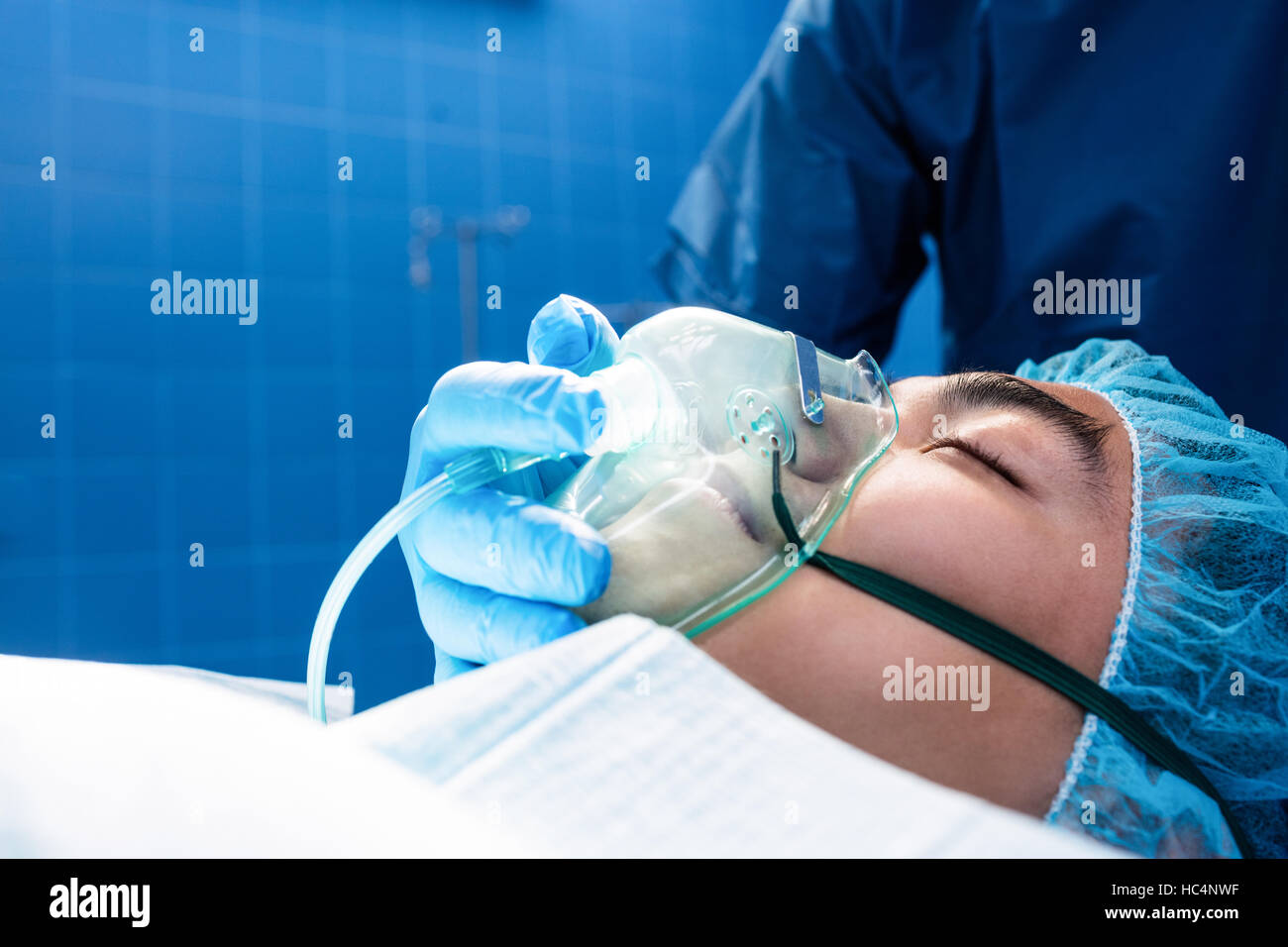 Surgeon placing an oxygen mask on the face of a patient Stock Photo - Alamy