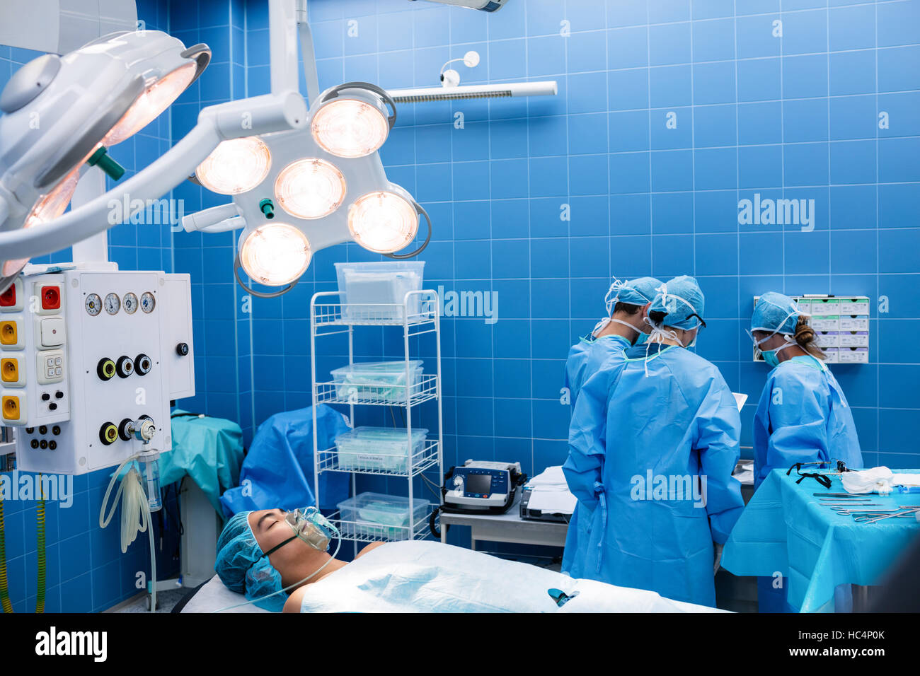 Surgeons interacting with each other while patient lying on operation ...