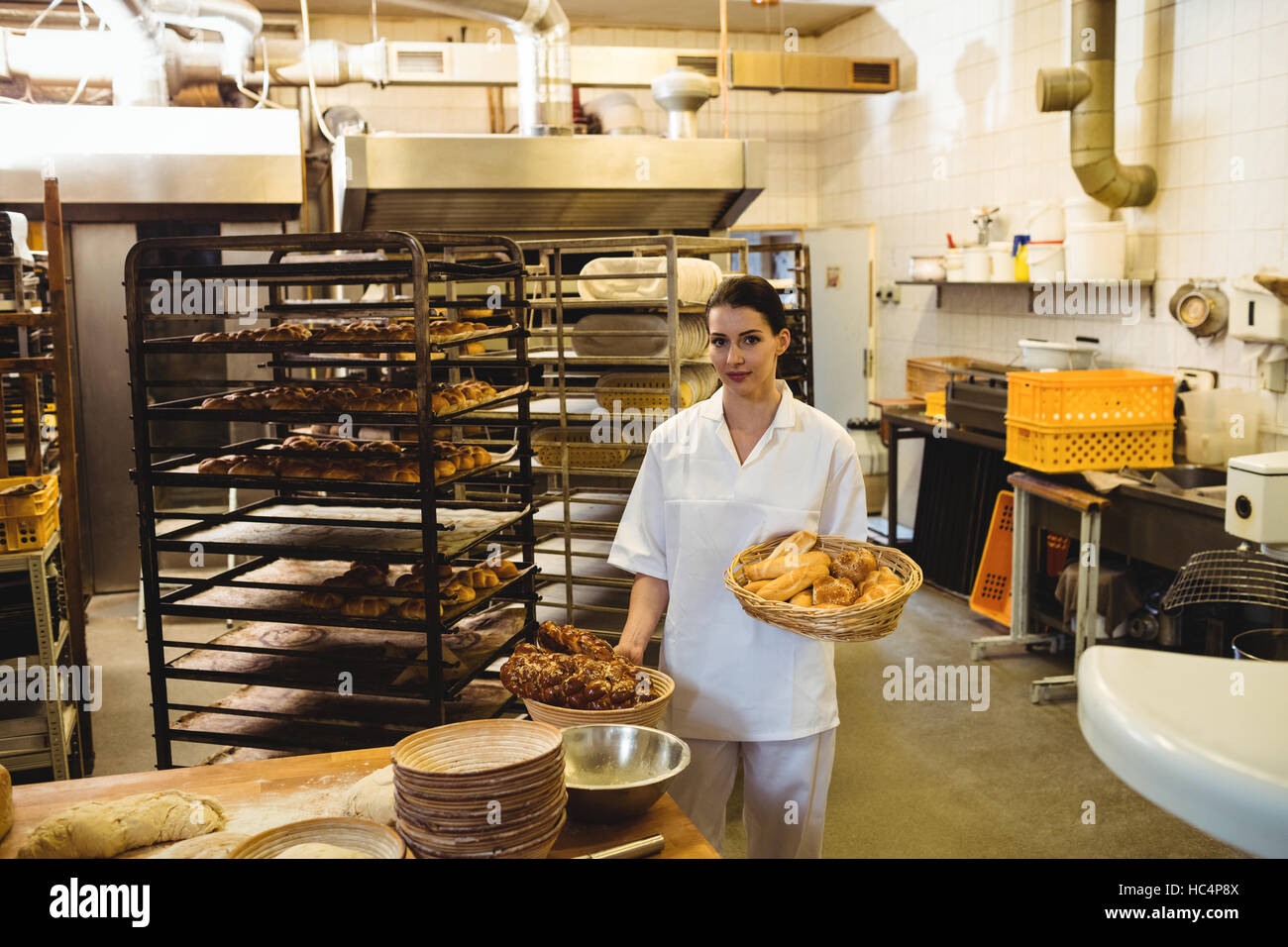 Female baker holding basket of sweet foods Stock Photo - Alamy