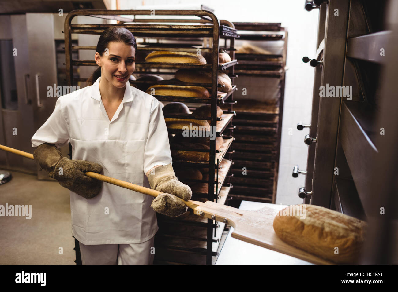 Female baker baking fresh bread Stock Photo - Alamy