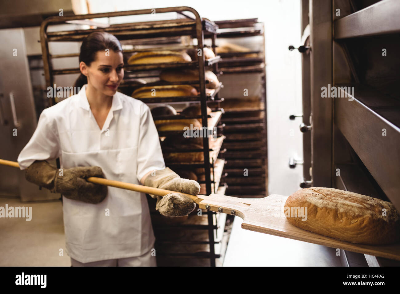 Female baker baking fresh bread Stock Photo - Alamy