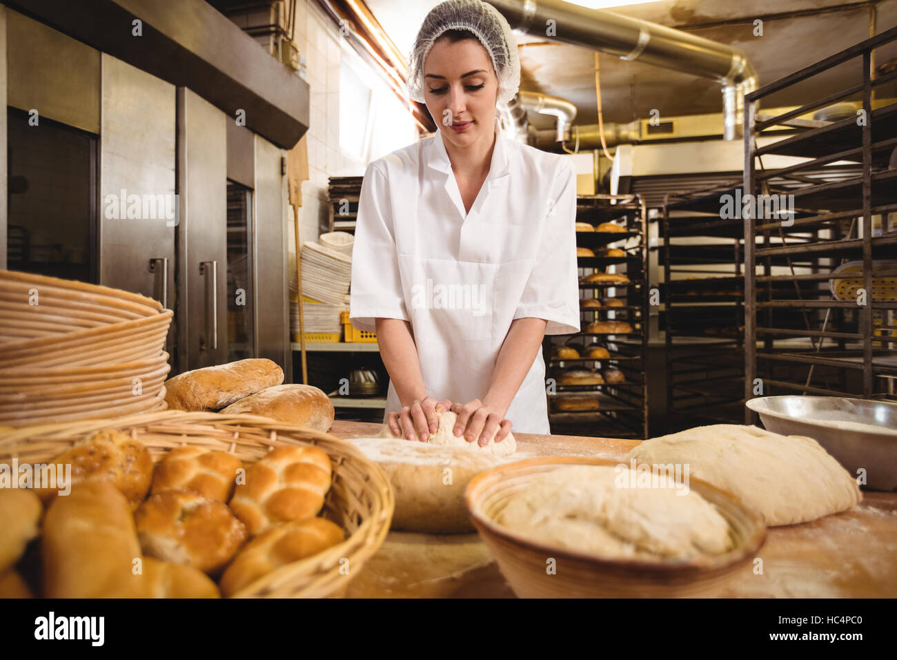 Female baker kneading a dough Stock Photo - Alamy