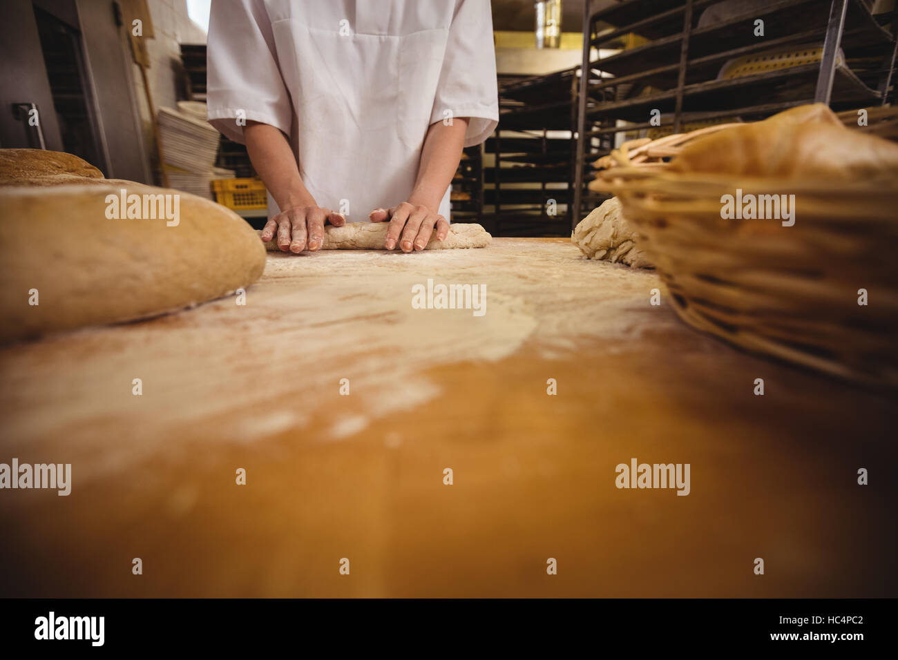 Mid-section of female baker kneading a dough Stock Photo - Alamy