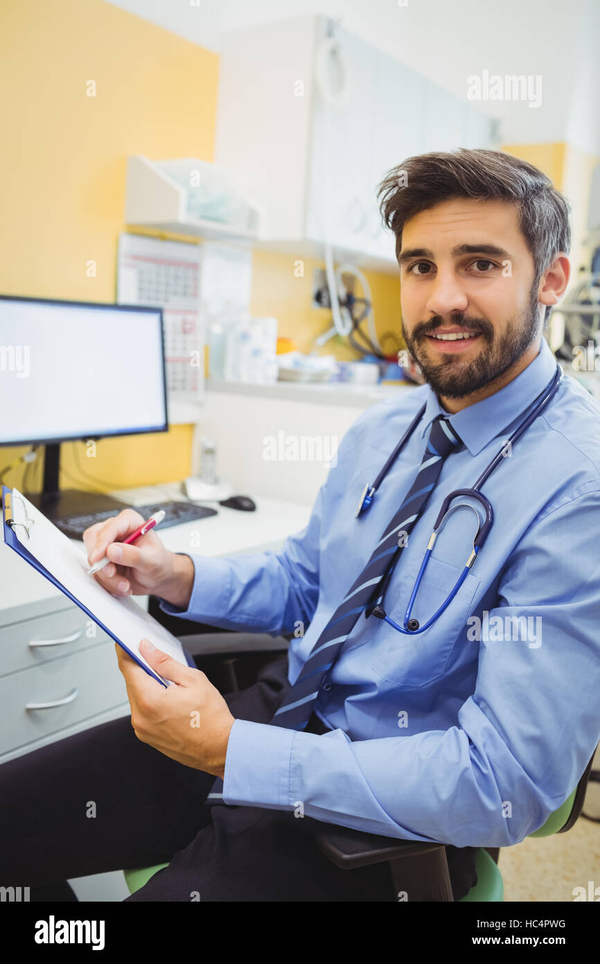 Portrait of doctor writing on a clipboard Stock Photo - Alamy