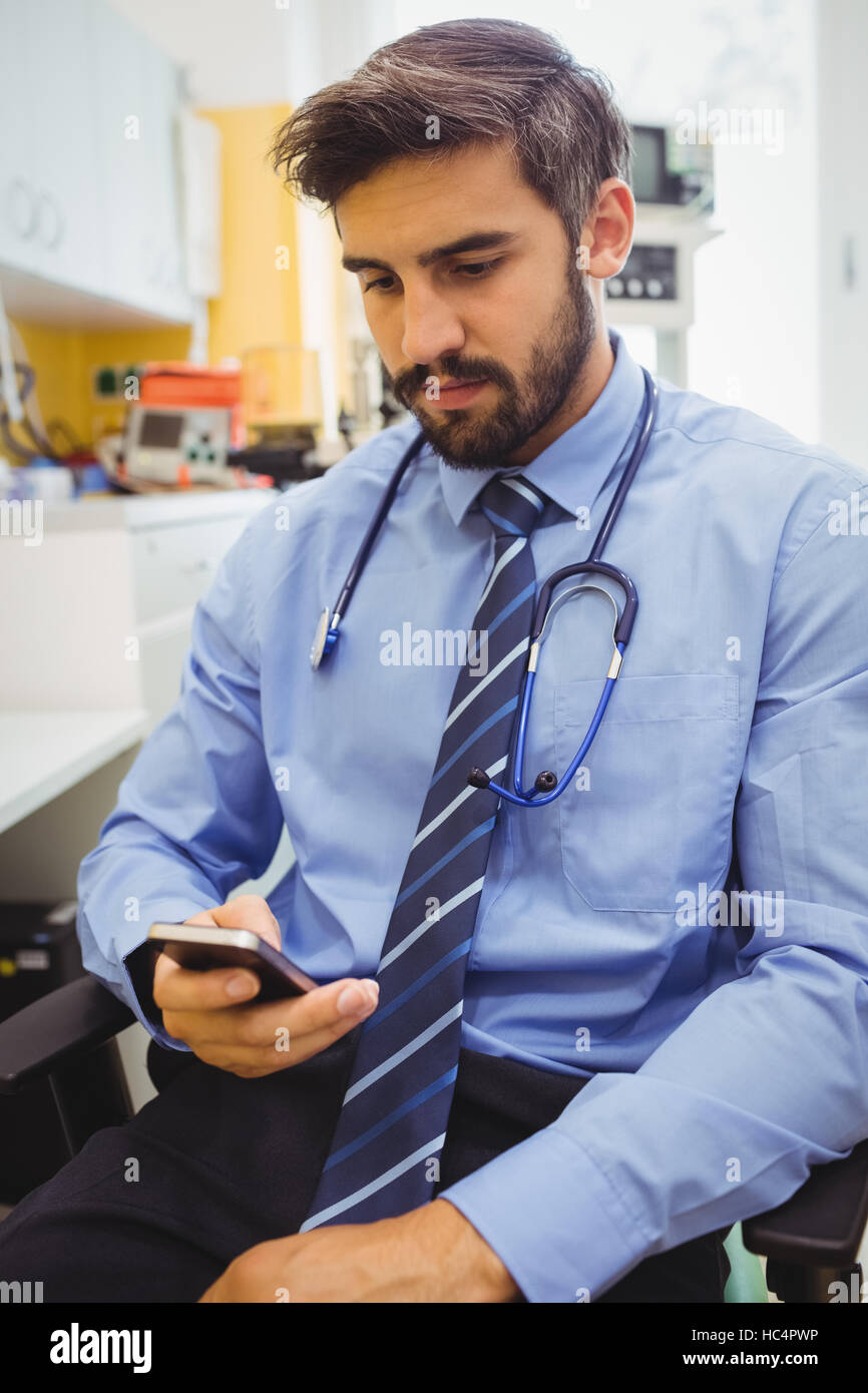 Doctor text messaging on mobile phone Stock Photo - Alamy