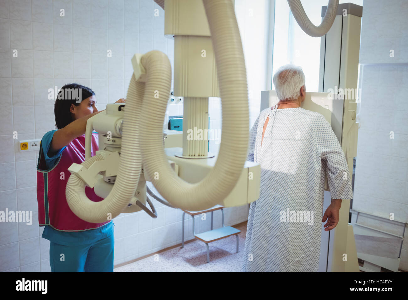 Female doctor sets up the machine to x-ray a patients spine Stock Photo ...