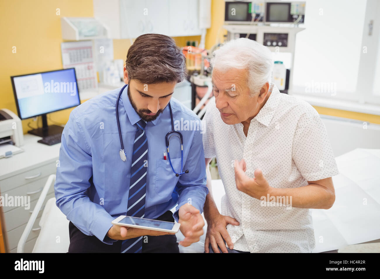 Doctor discussing with patient over digital tablet Stock Photo - Alamy