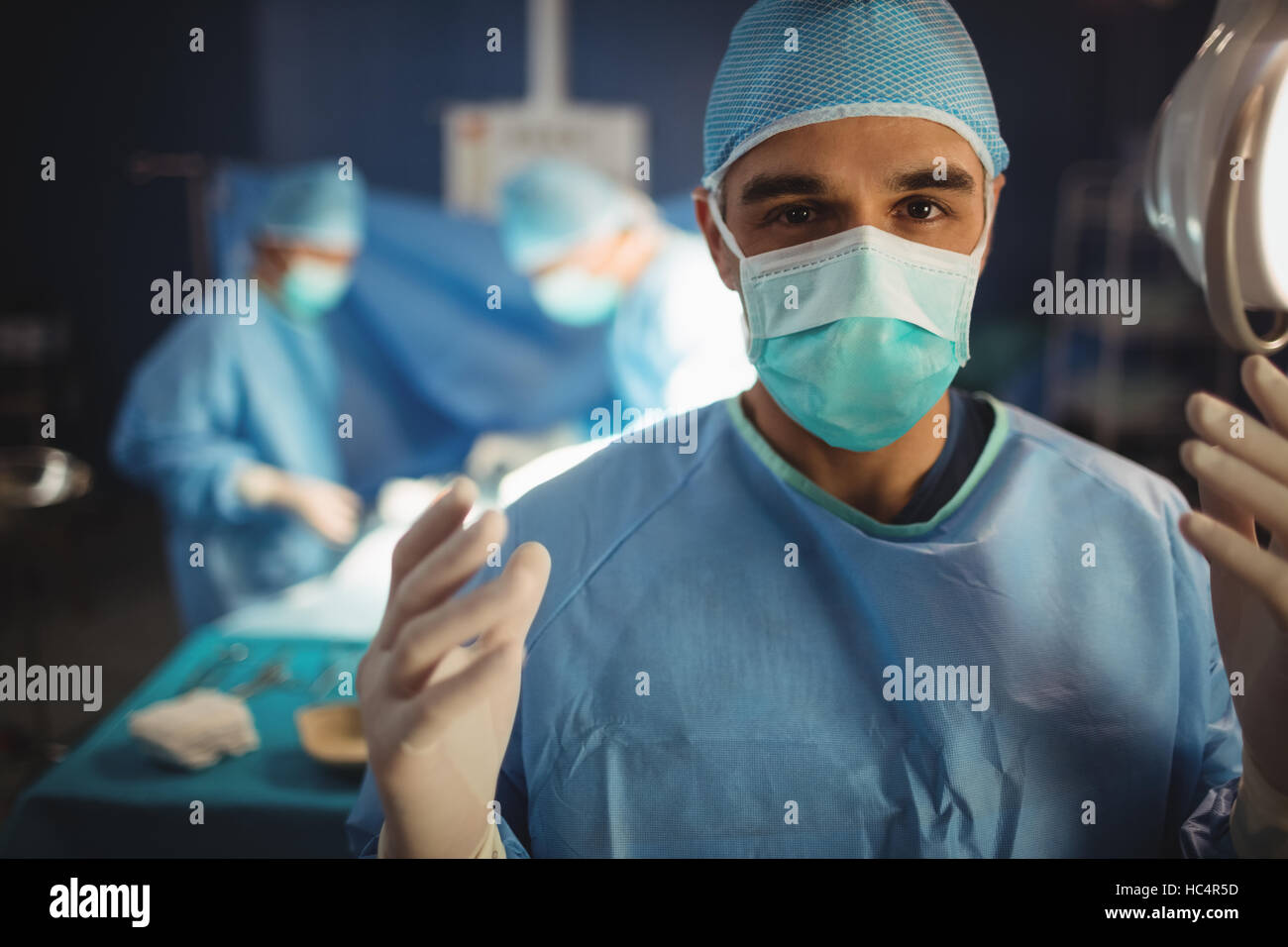 Portrait of male surgeon preparing for operation in operation room ...