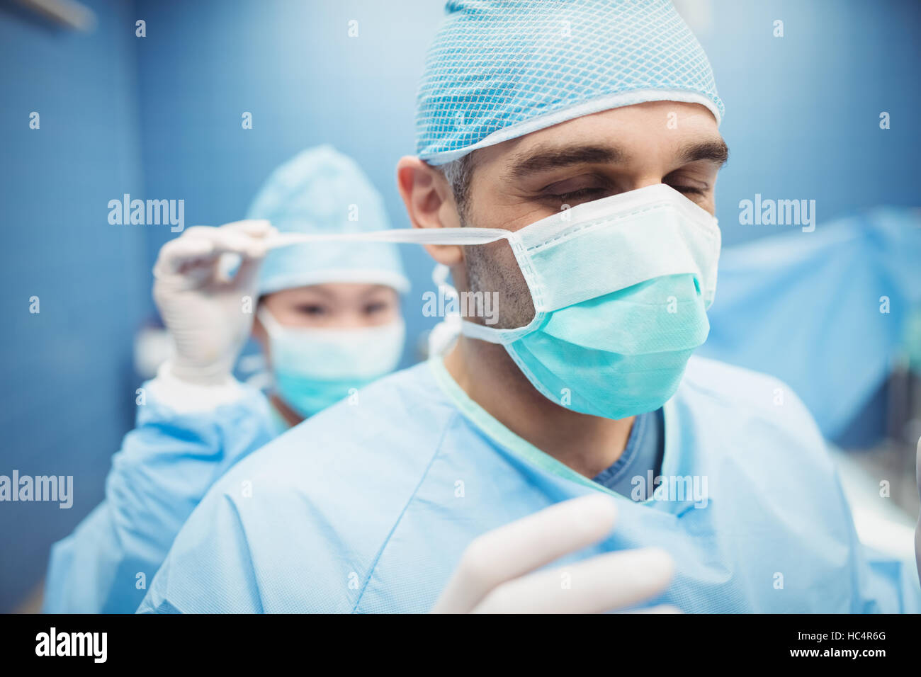 Nurse helping a surgeon in tying surgical mask Stock Photo - Alamy