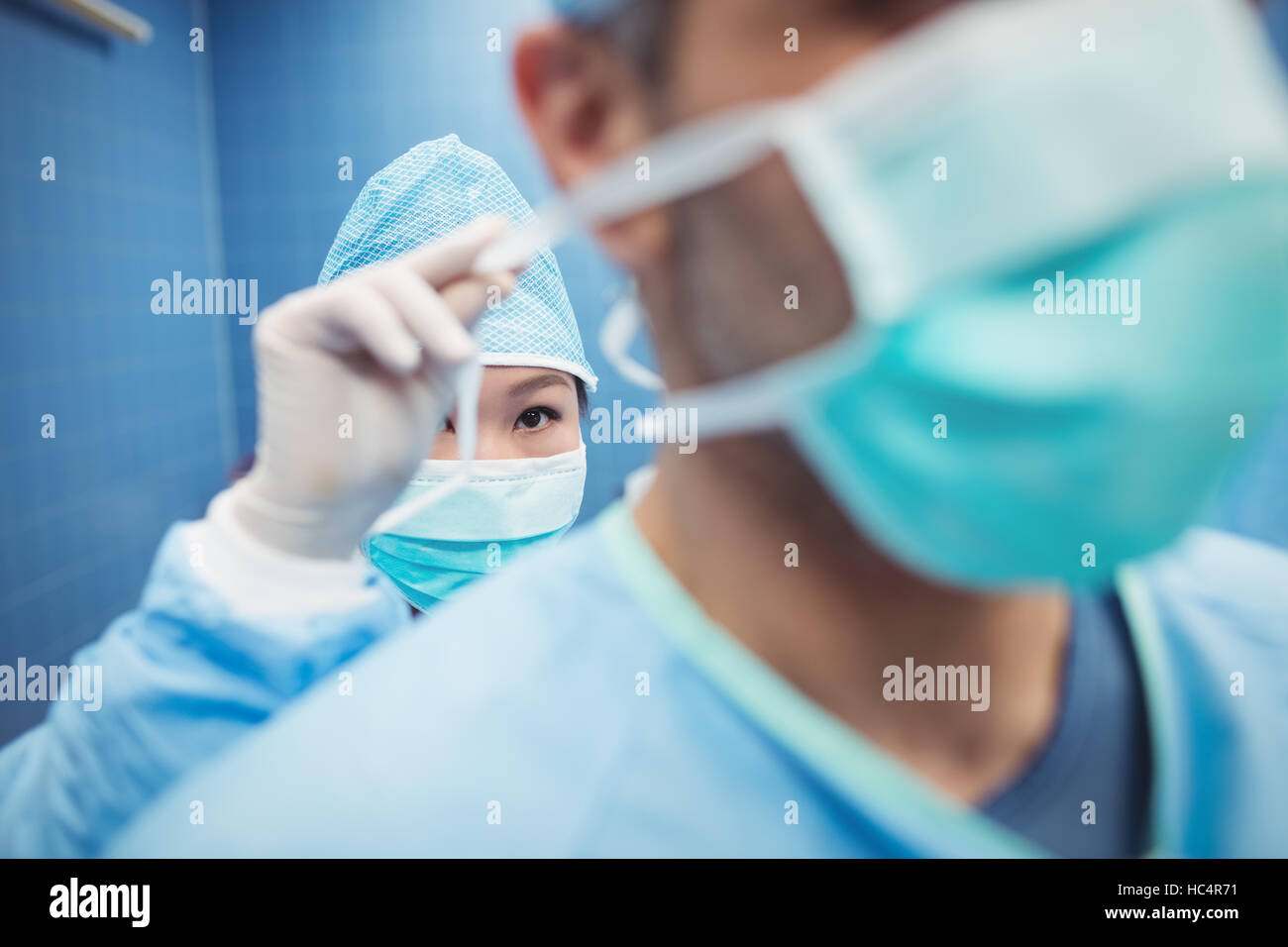 Nurse helping a surgeon in tying surgical mask Stock Photo - Alamy