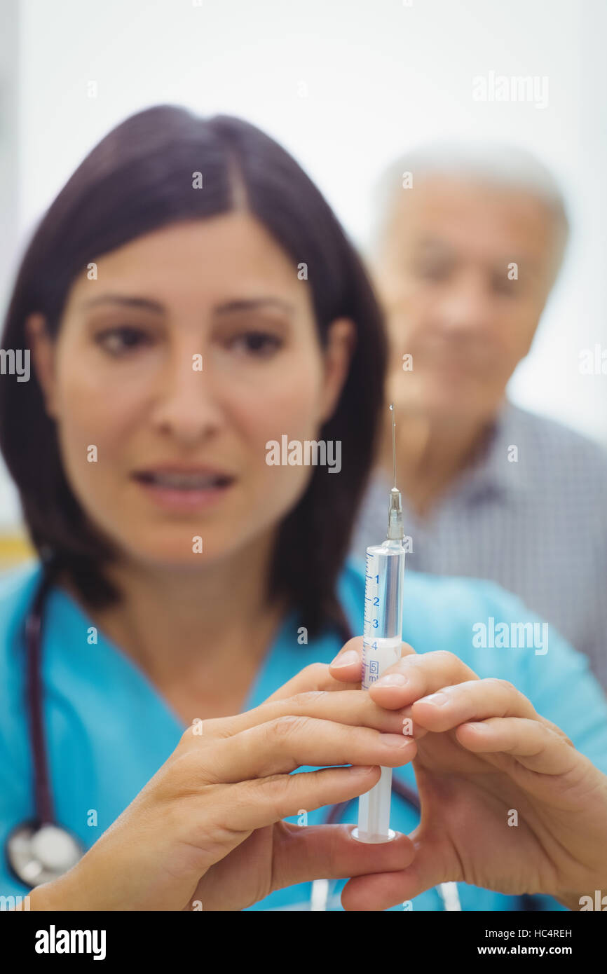 Female doctor holding an injection Stock Photo - Alamy