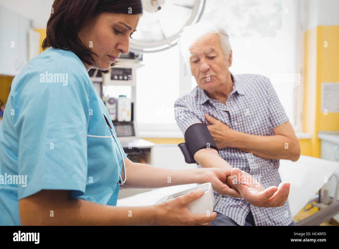 Female doctor checking blood pressure of patient Stock Photo - Alamy