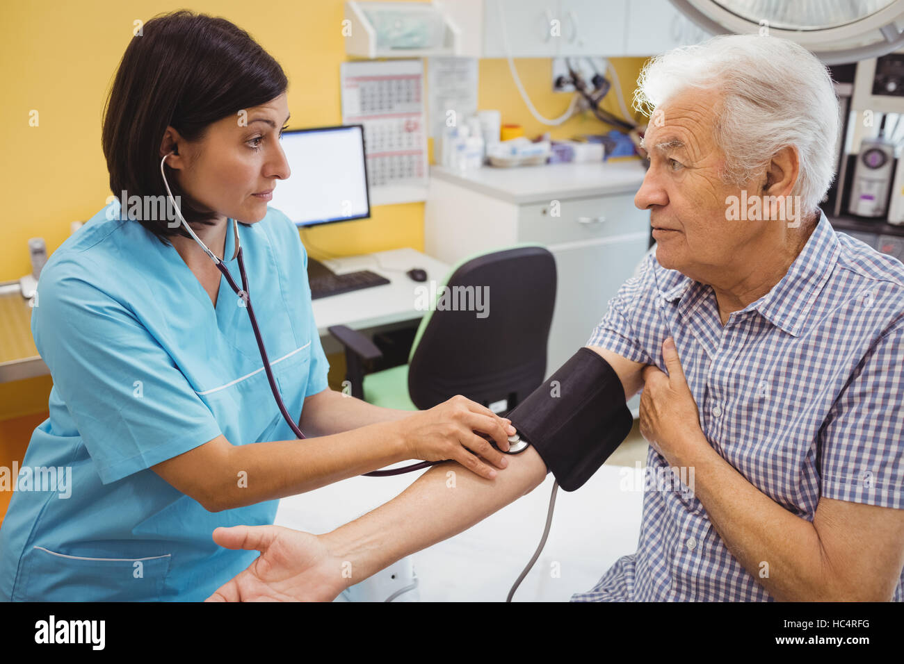 Female doctor checking blood pressure of patient Stock Photo - Alamy