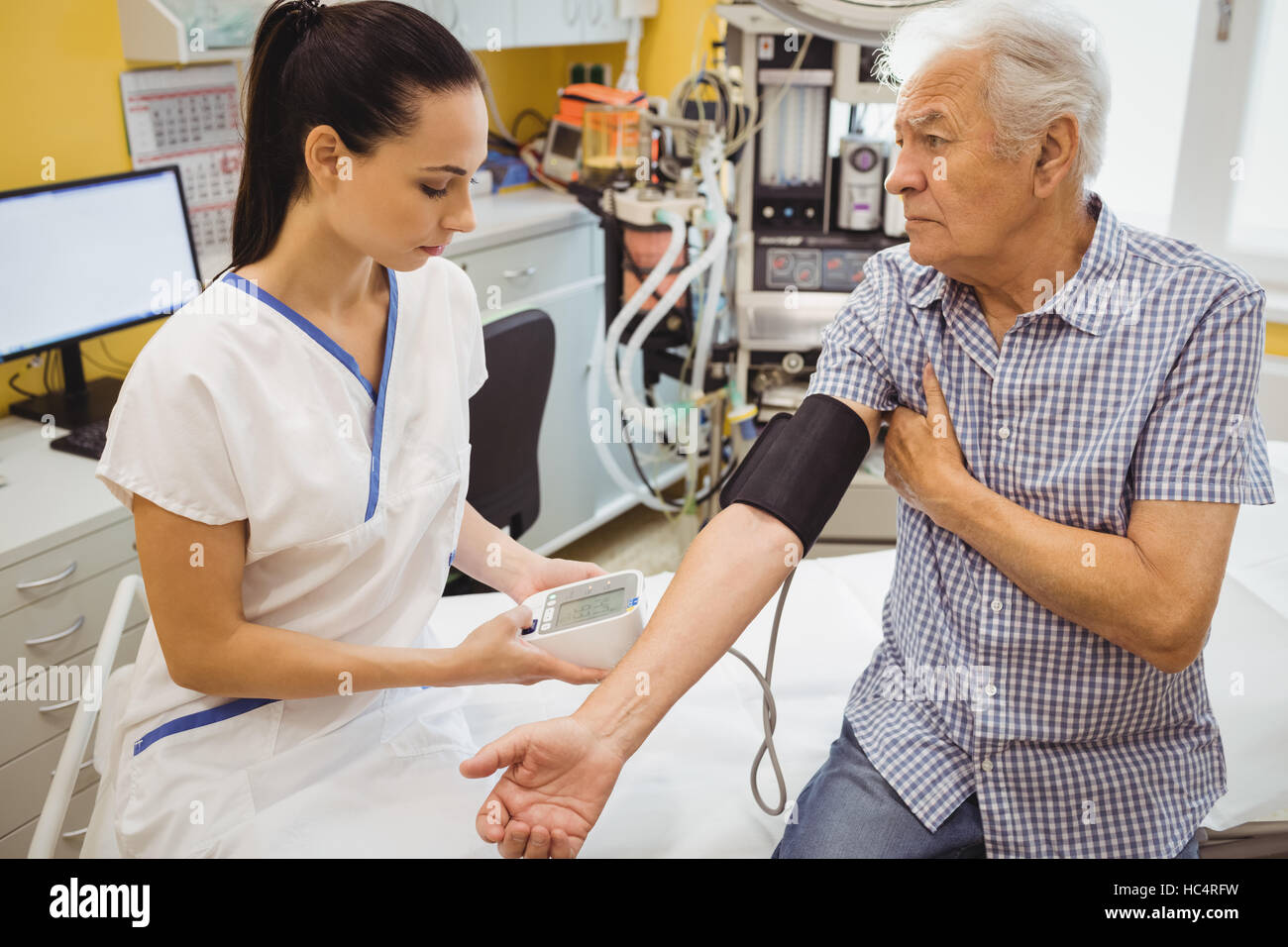 Female doctor checking blood pressure of patient Stock Photo - Alamy