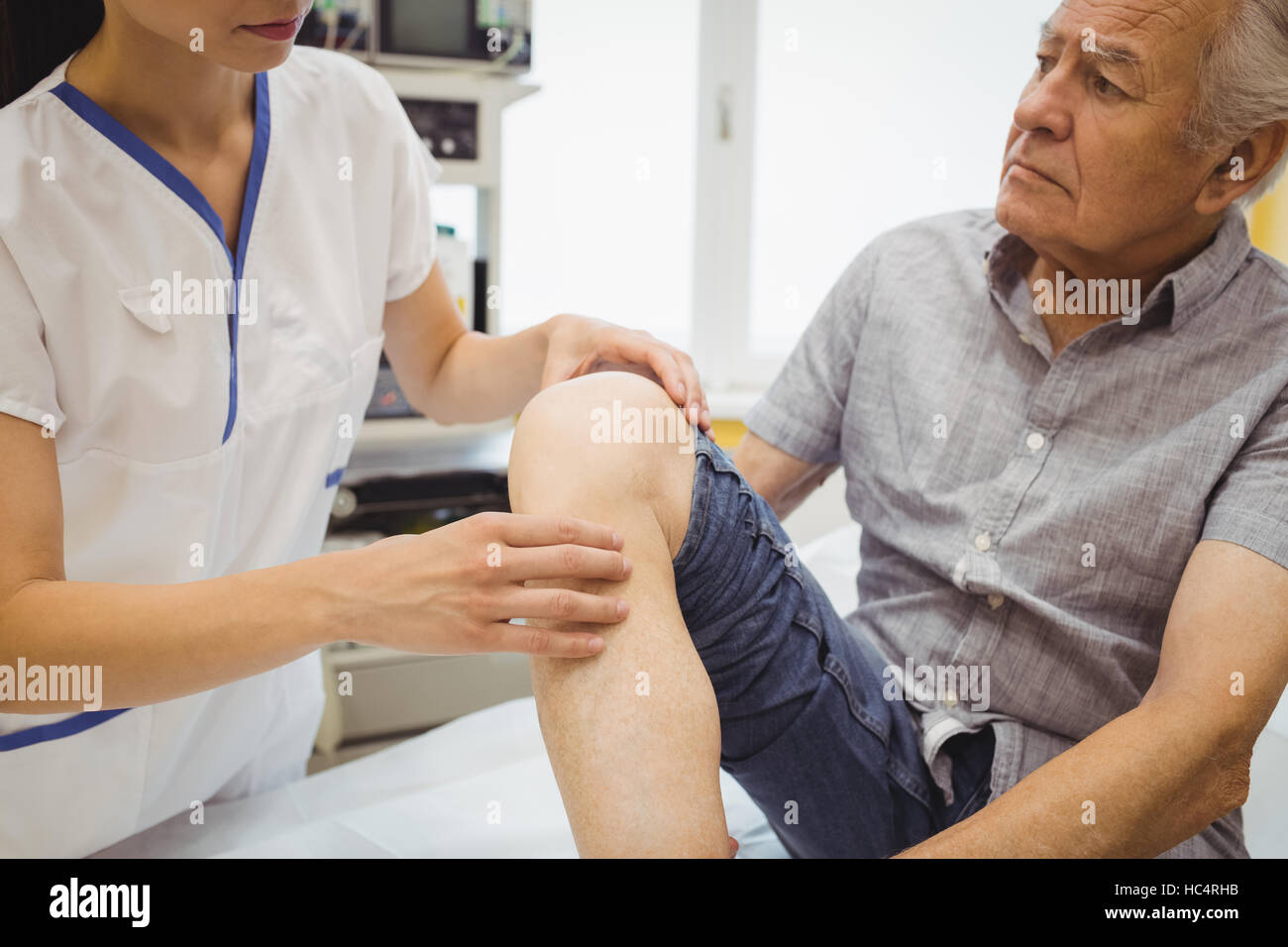Female doctor examining patients knee Stock Photo - Alamy