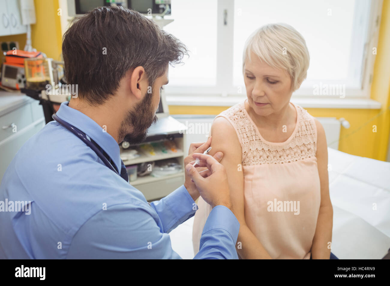 Male doctor giving an injection to a patient Stock Photo - Alamy