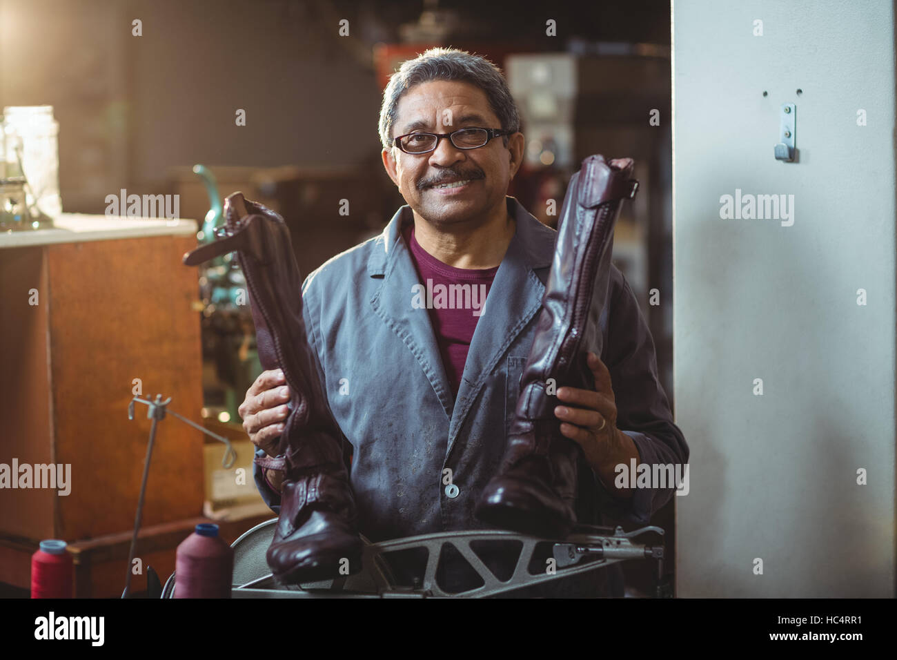 Portrait of shoemaker standing with long boots Stock Photo - Alamy
