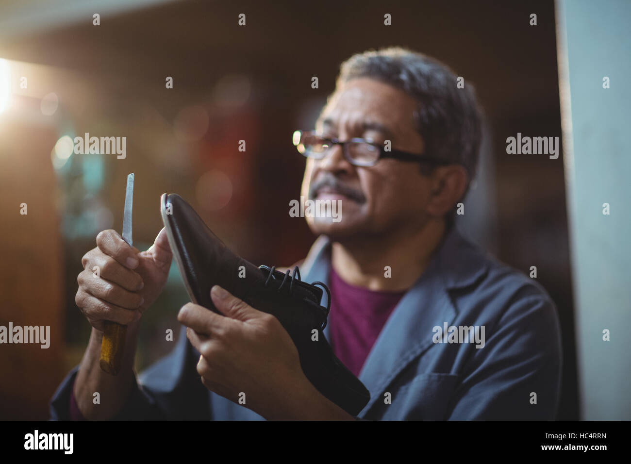 Shoemaker repairing a shoe Stock Photo - Alamy