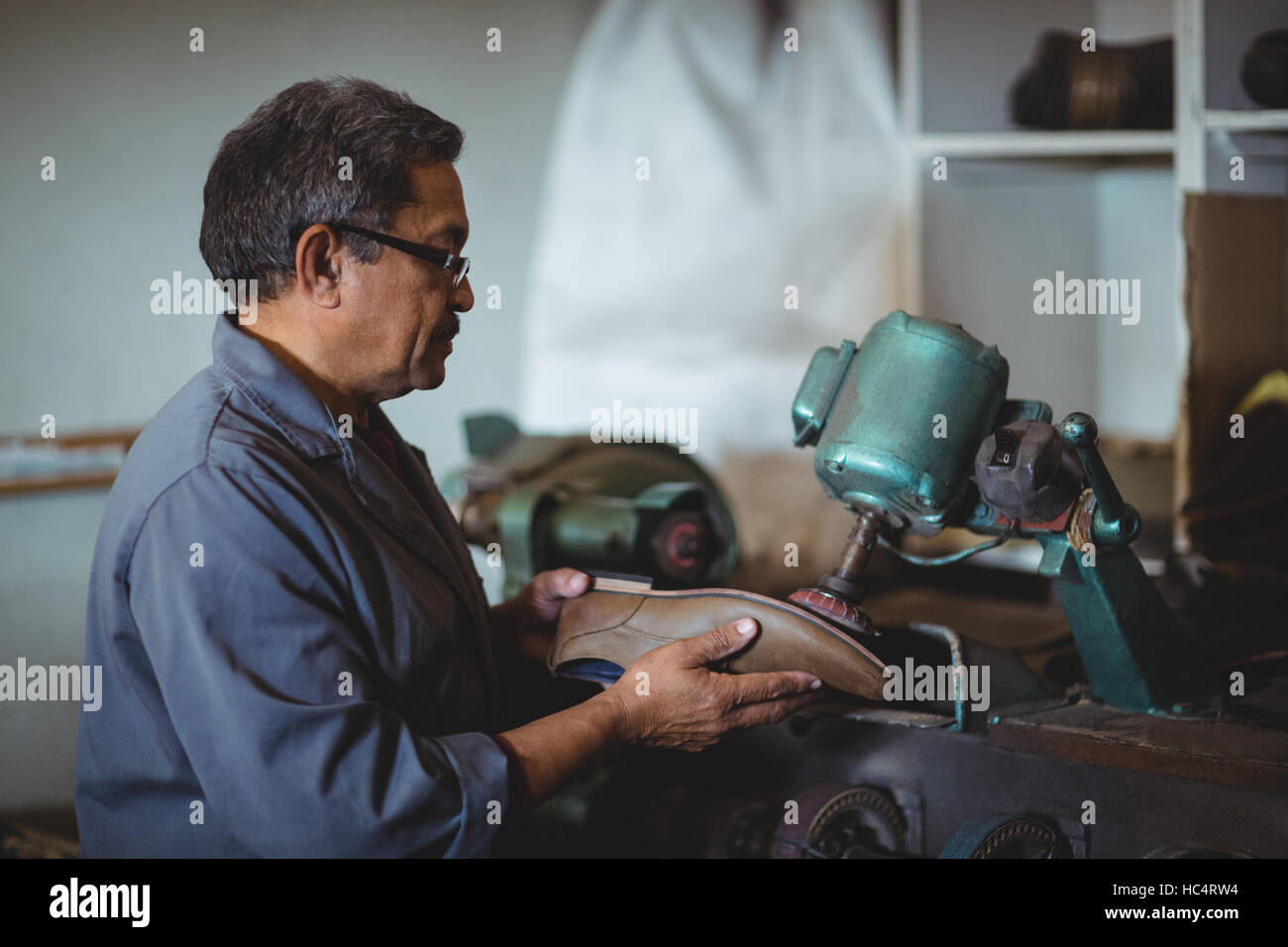 Shoemaker polishing a shoe with machine Stock Photo - Alamy