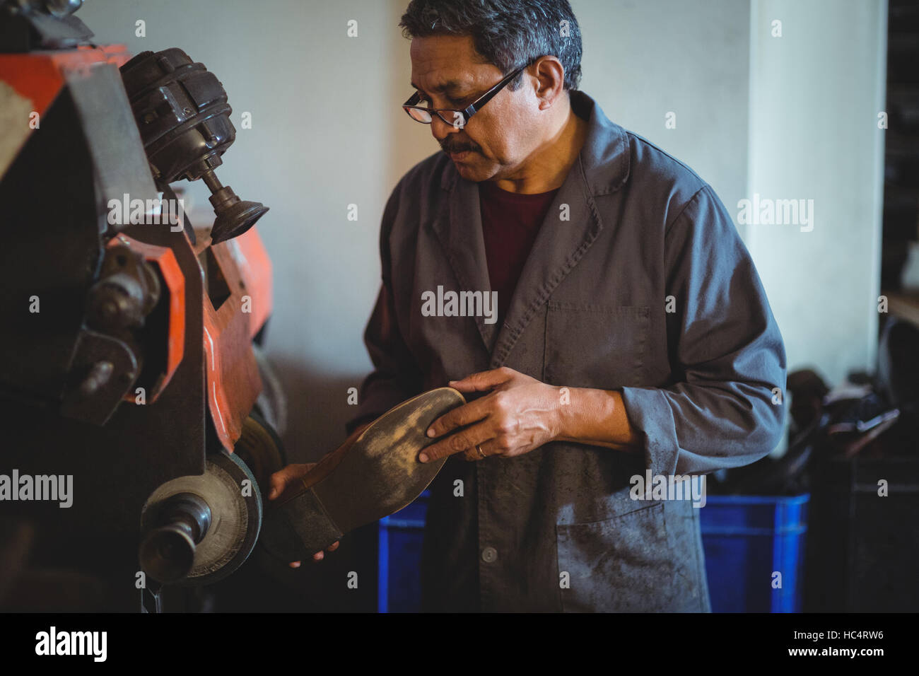Shoemaker polishing a shoe with machine Stock Photo - Alamy