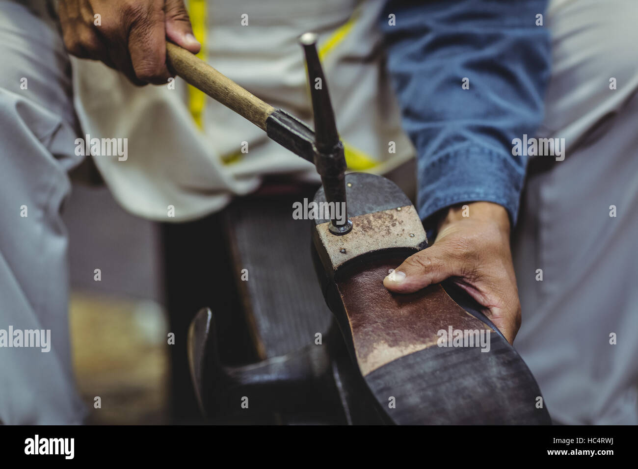 Shoemaker hammering on a shoe Stock Photo - Alamy