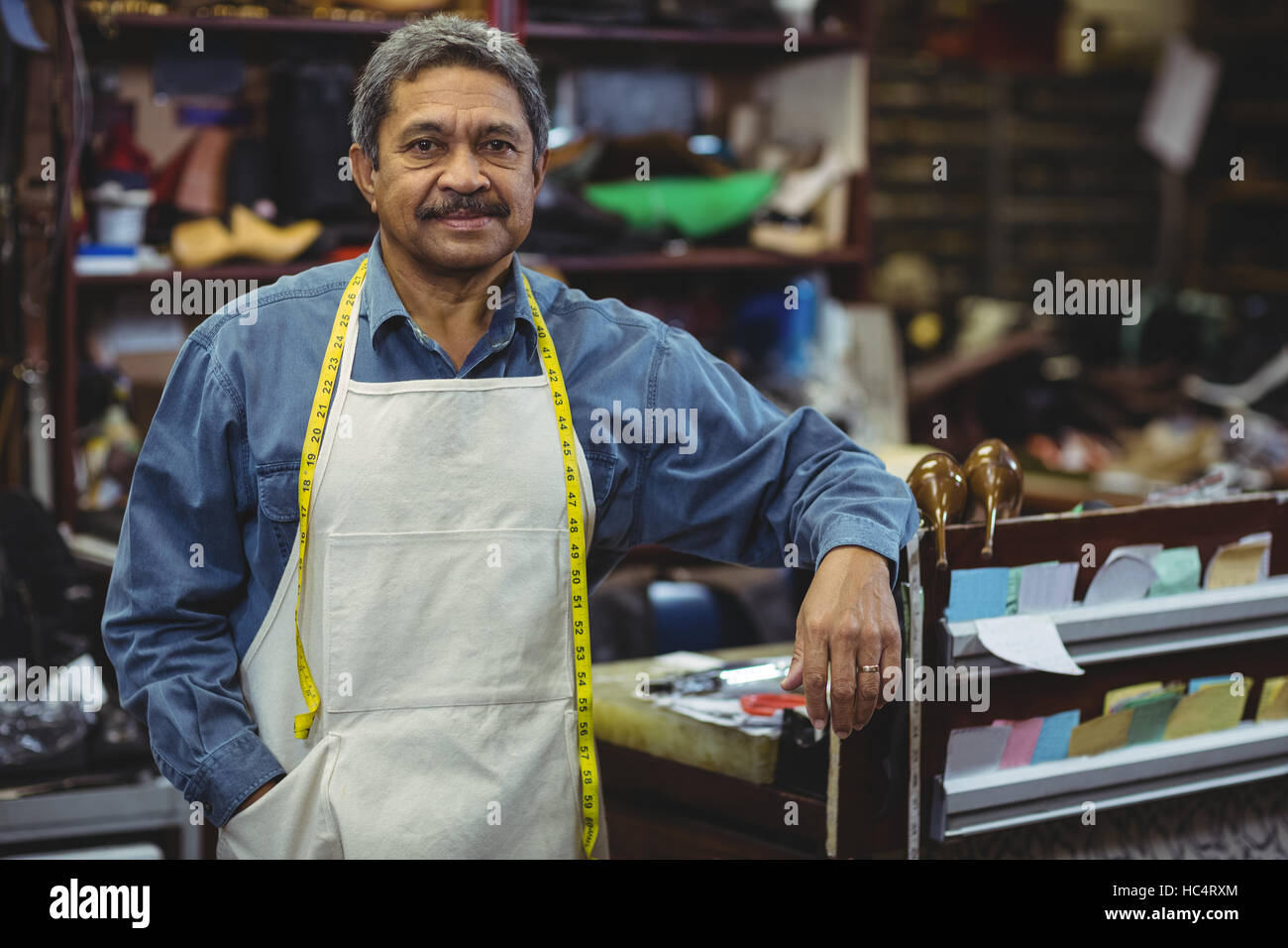 Portrait of shoemaker standing with hand in pocket Stock Photo - Alamy