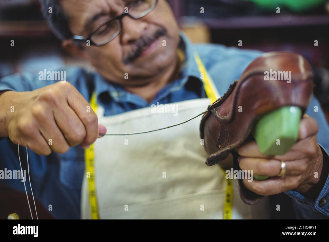 Shoemaker repairing a shoe Stock Photo - Alamy