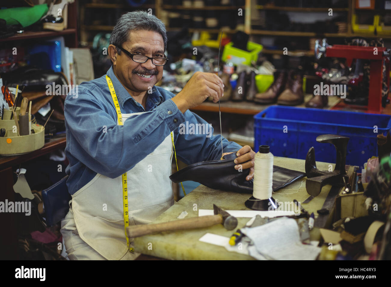 Shoemaker stitching shoe sole with needle Stock Photo - Alamy