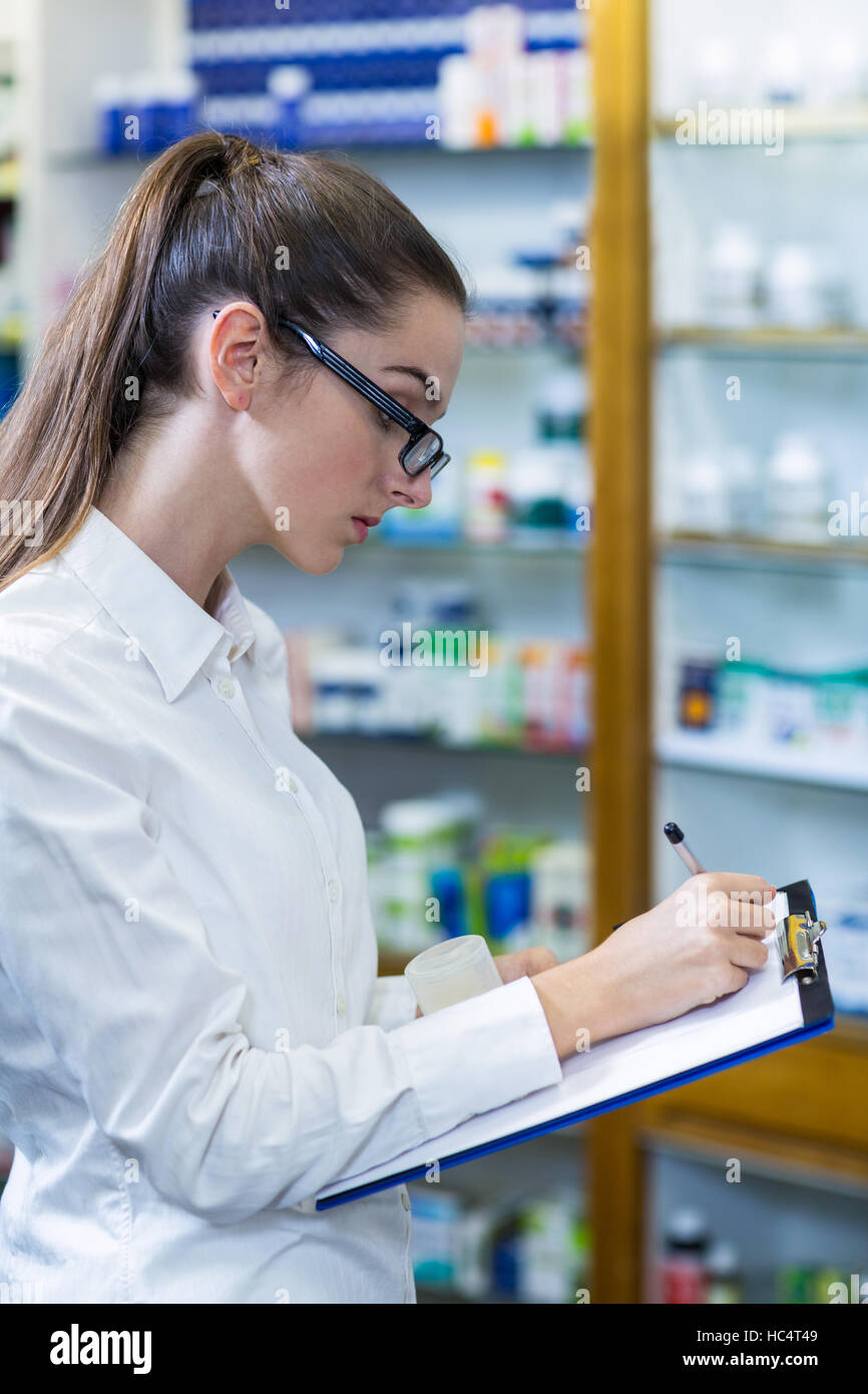 Pharmacist writing on clipboard Stock Photo - Alamy