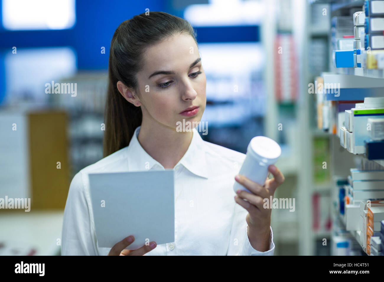 Pharmacist holding prescription while checking medicine Stock Photo - Alamy