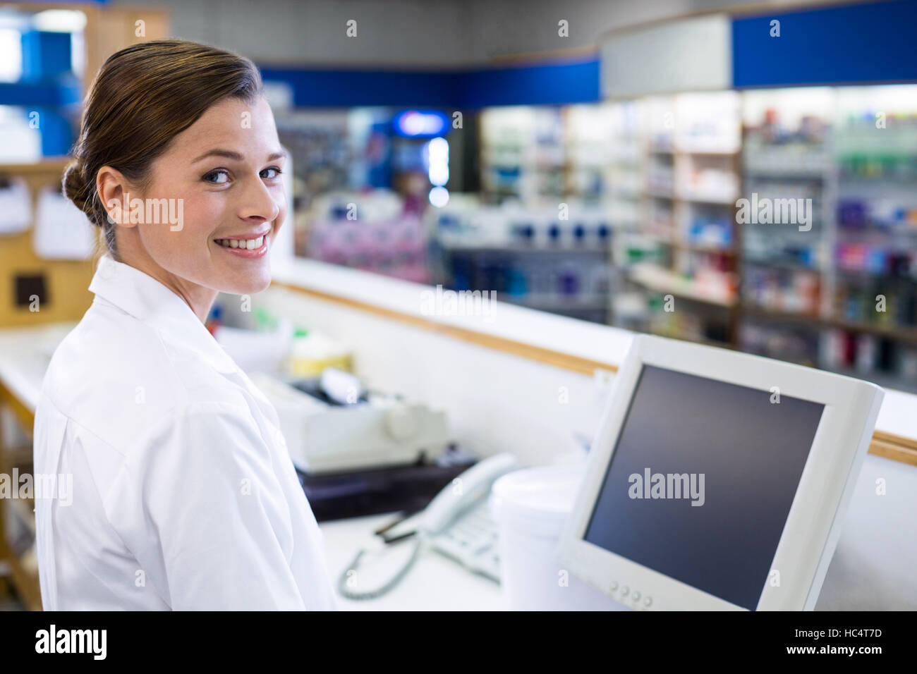 Smiling pharmacist standing at counter in pharmacy Stock Photo - Alamy