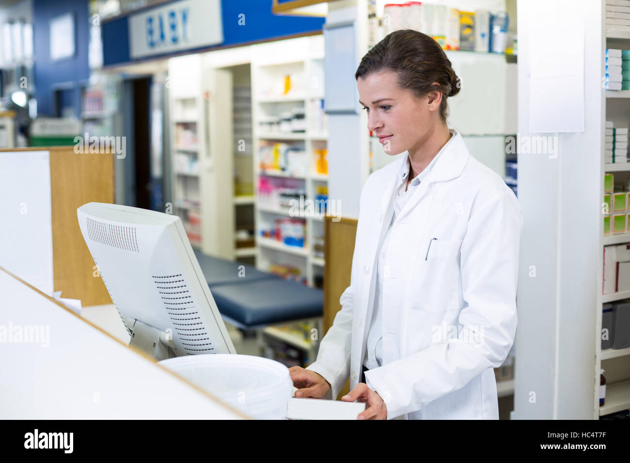 Pharmacist making prescription record through computer Stock Photo - Alamy