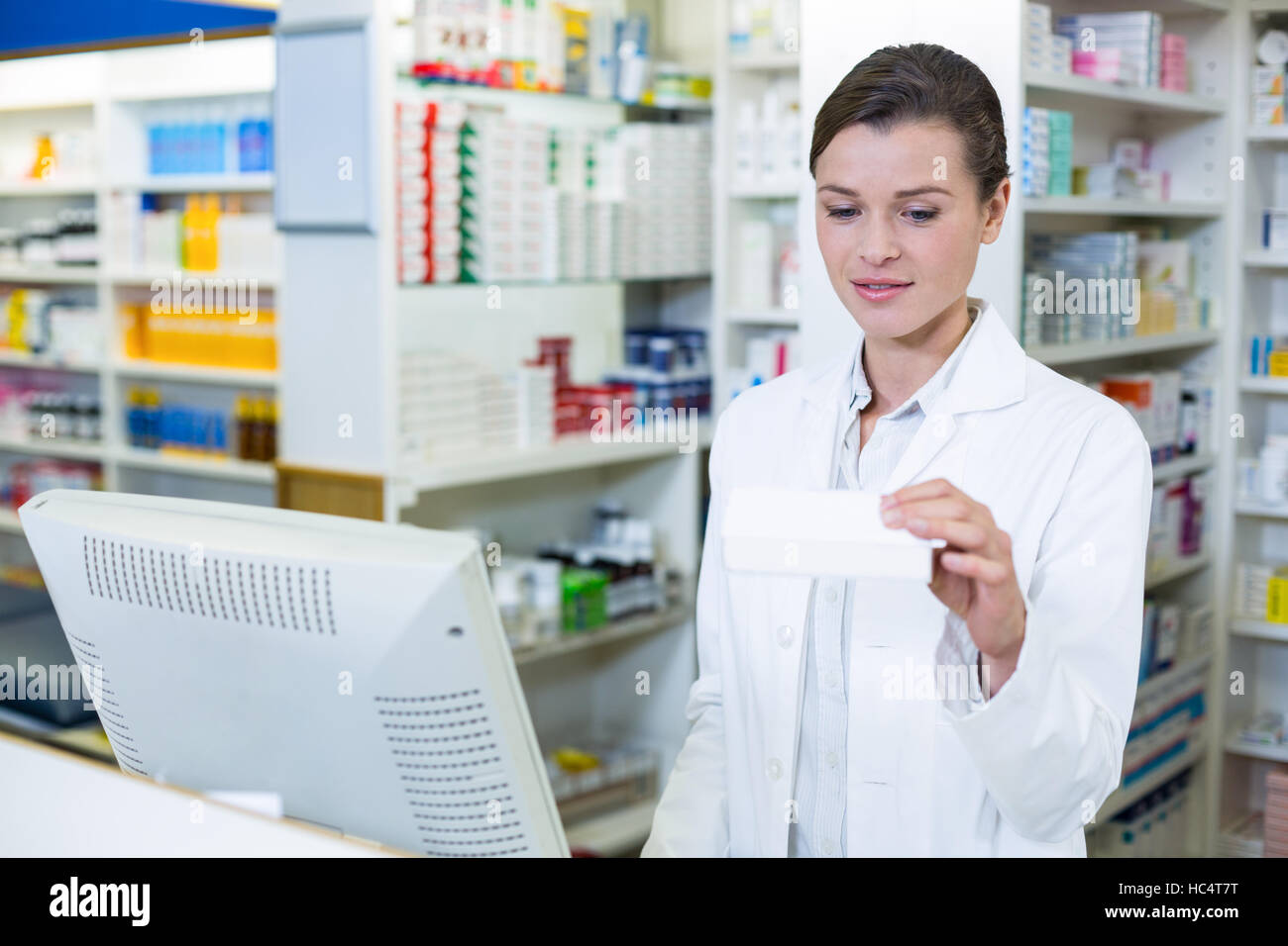 Pharmacist making prescription record through computer Stock Photo - Alamy