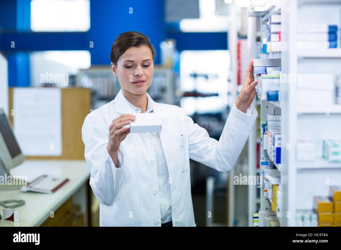 Pharmacist checking medicine in shelf Stock Photo - Alamy