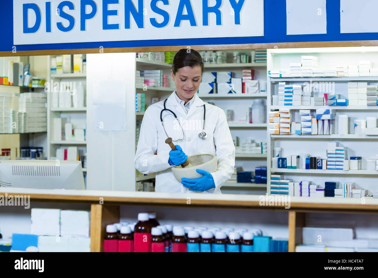 Pharmacist grinding medicine in mortal and pestle at counter Stock ...