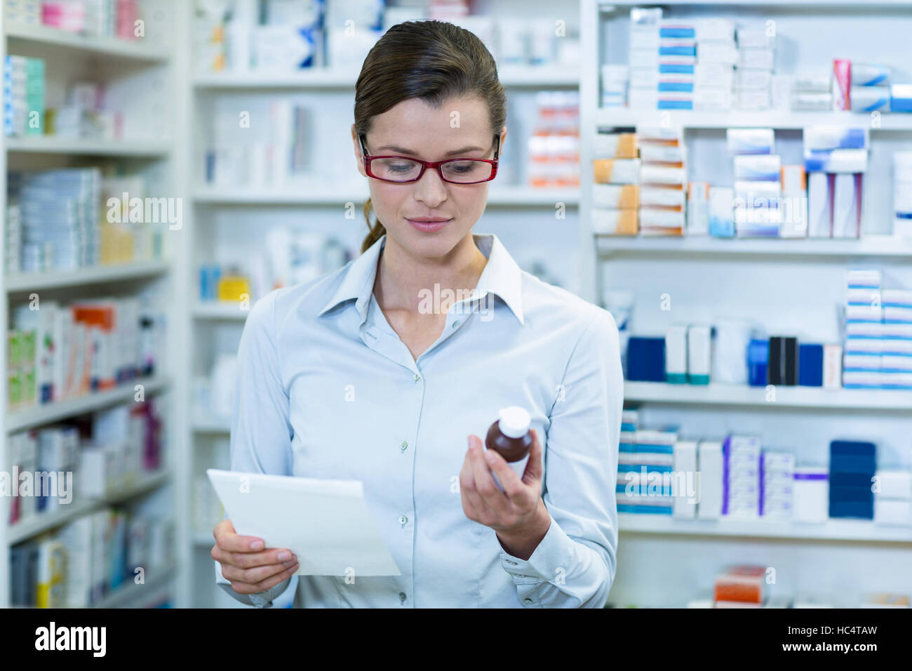 Pharmacist checking at prescription and medicine container Stock Photo ...