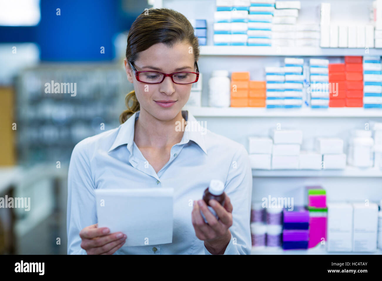 Pharmacist checking at prescription and medicine container Stock Photo ...
