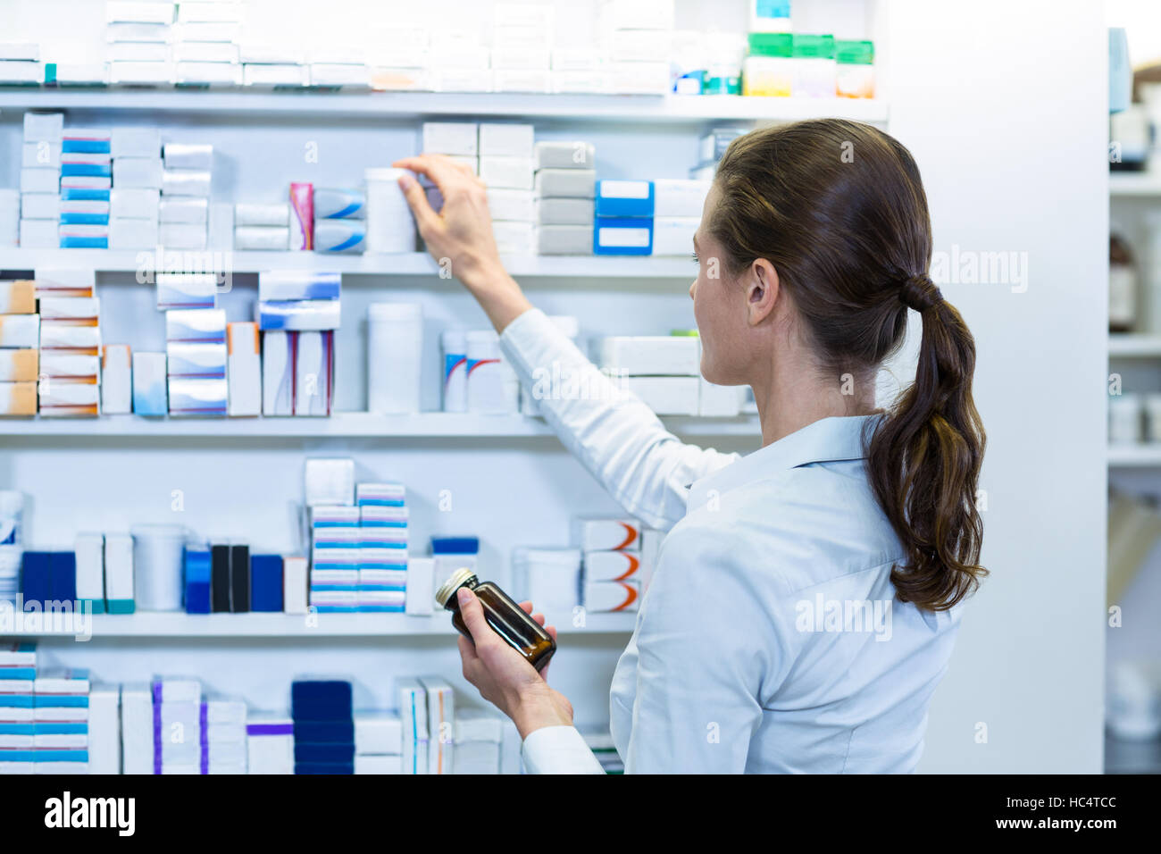 Pharmacist checking medicine in shelf Stock Photo - Alamy