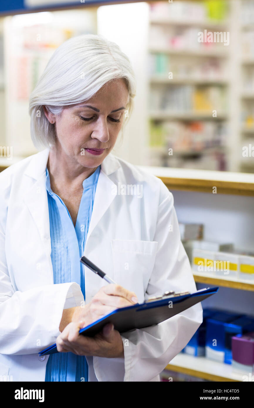 Pharmacist writing on clipboard Stock Photo - Alamy